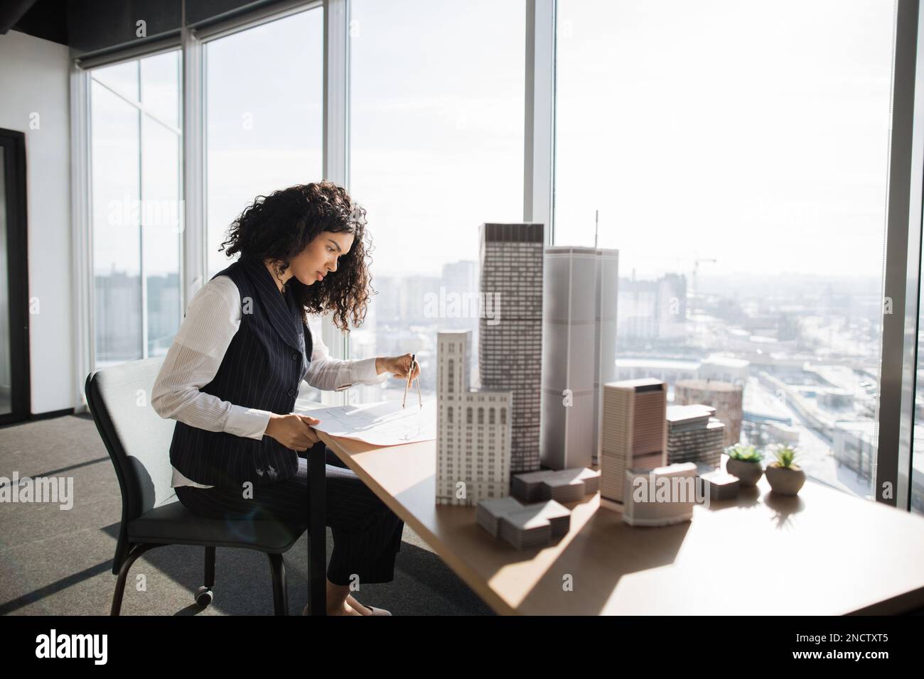 Curly female engineer working on building complex prototype project of ...