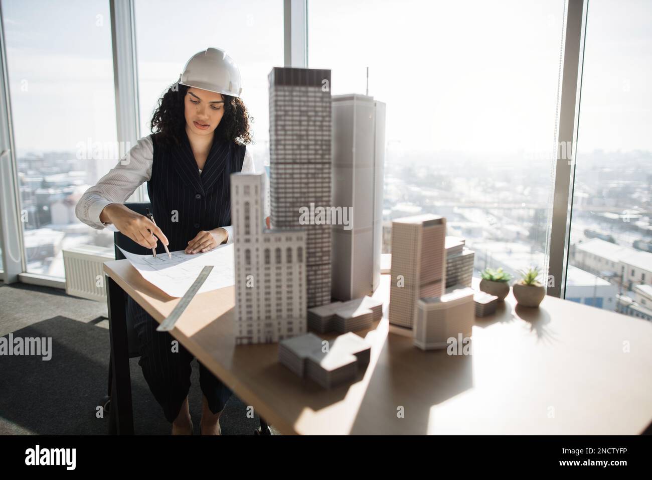 Young female engineer in white helmet working on building complex ...