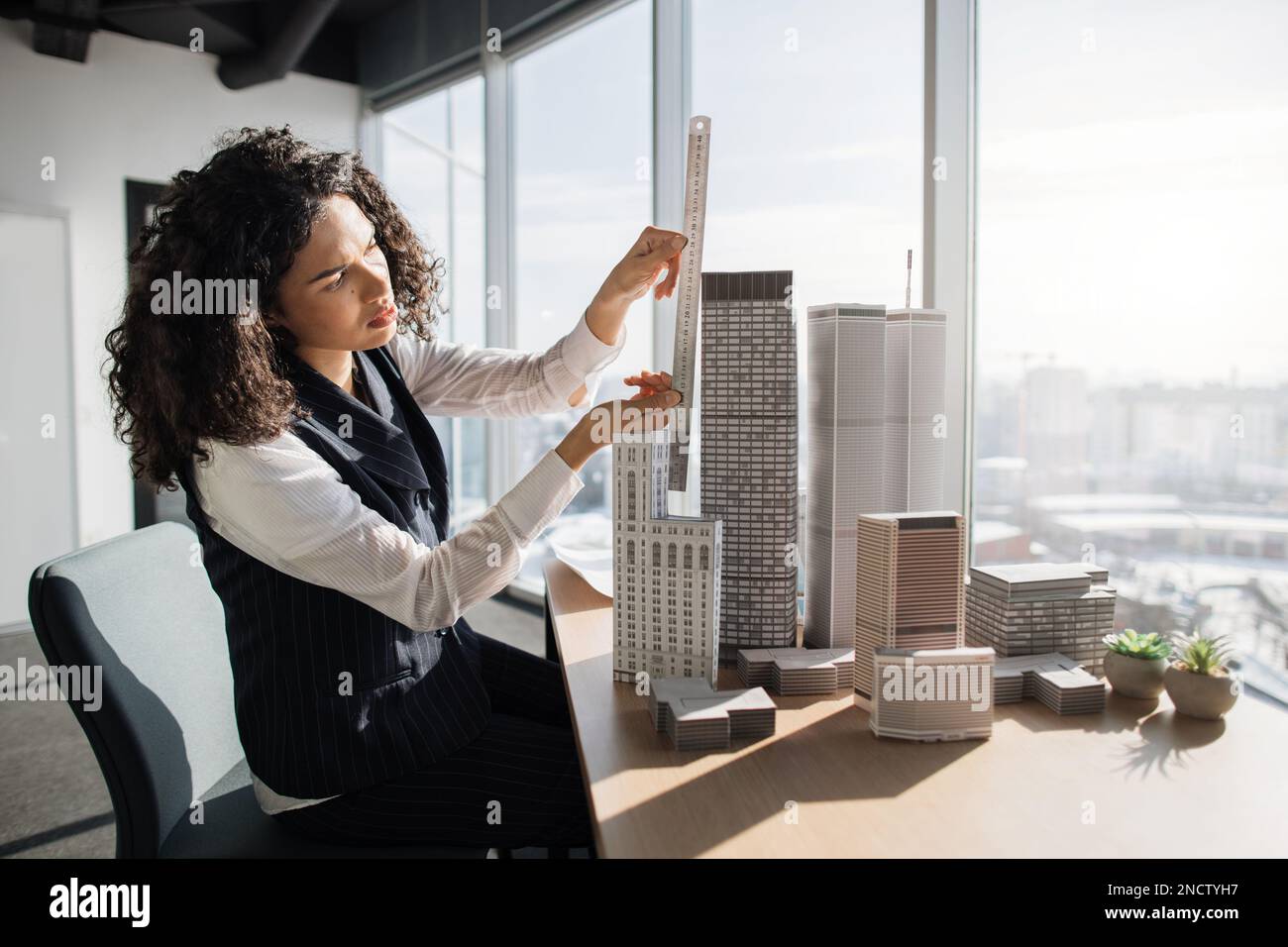 Curly female engineer working on building complex prototype project of ...