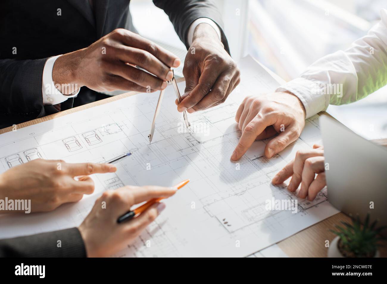 Close up of architects, engineers and designers sitting together at ...