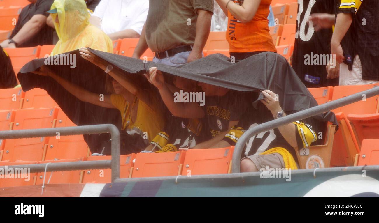 Pittsburgh Steelers fans take cover from the rain during an NFL ...
