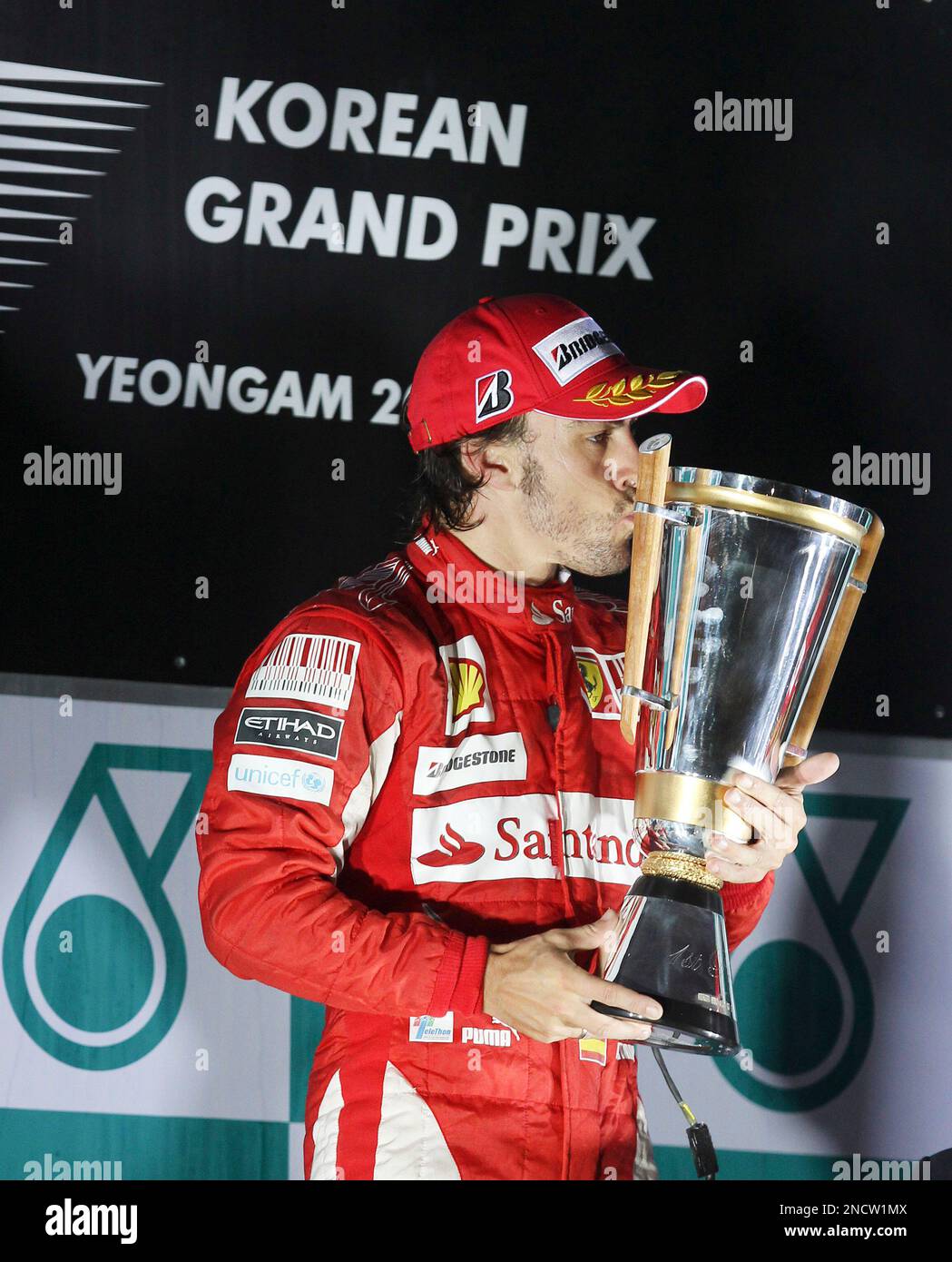 Ferrari Formula One driver Fernando Alonso of Spain kisses his trophy ...
