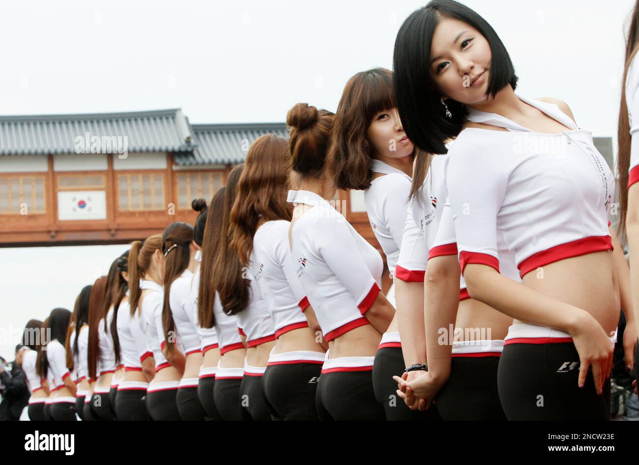 A line of "racing girls" wait on a red carpet for the Formula One ...
