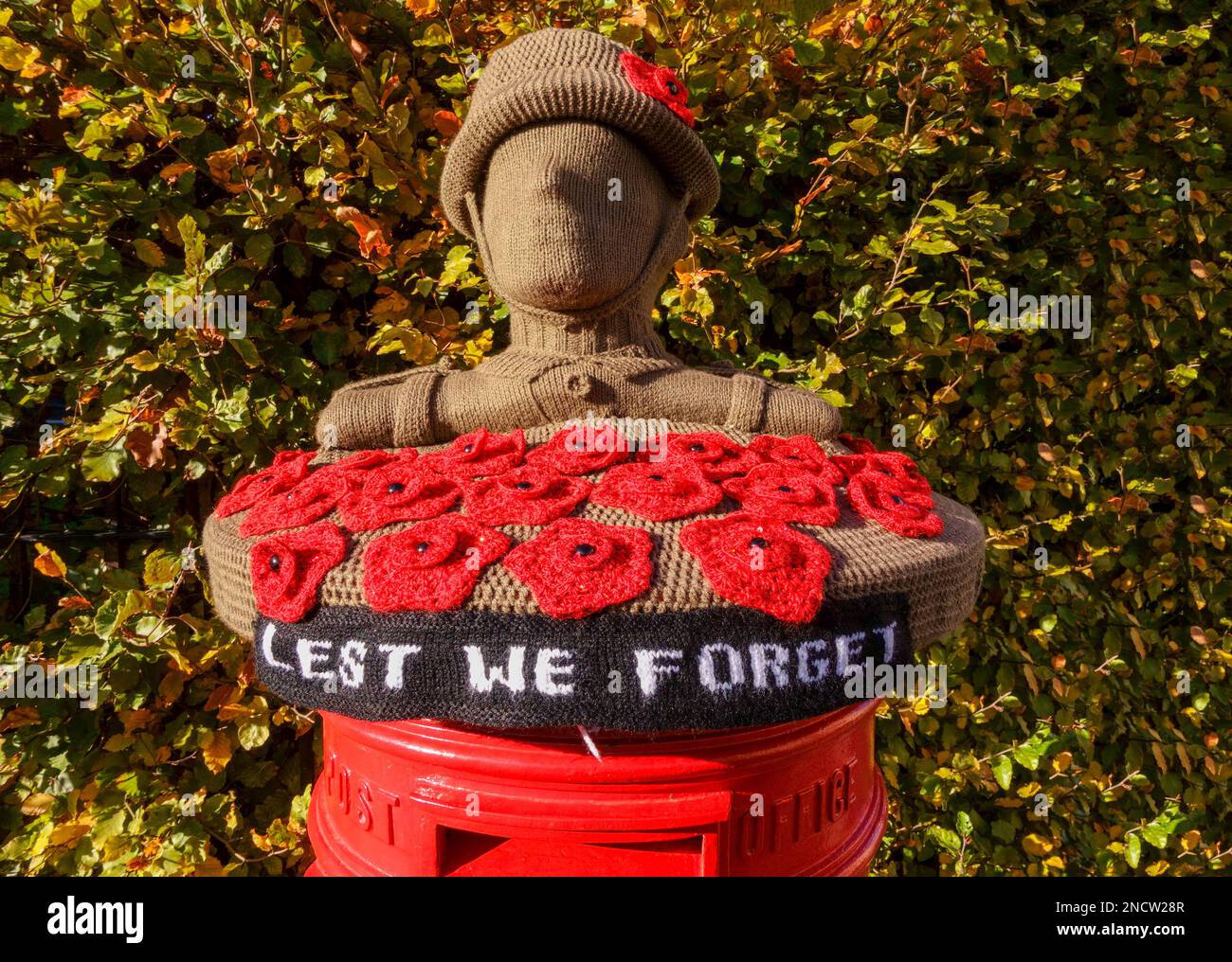 Knitted pillarbox cover with soldiers bust and poppies to commemorate ...