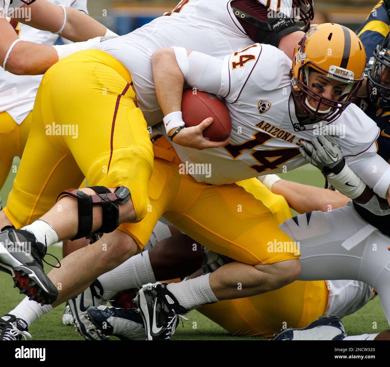 Arizona State quarterback Steven Threet (14) is pulled down by ...