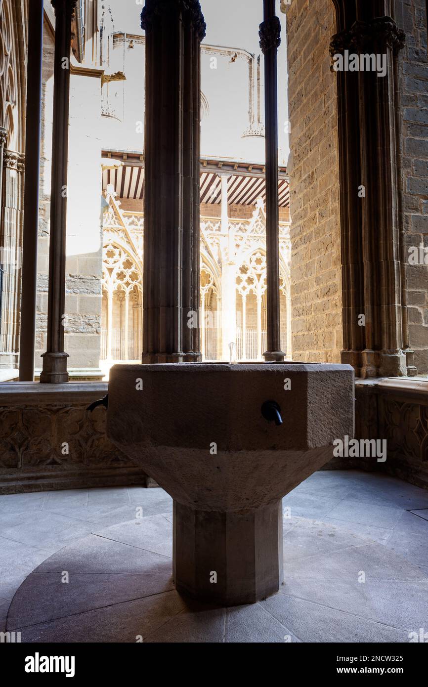 The Holy Water stoup in the ornate gothic cloister arcade arches of the ...