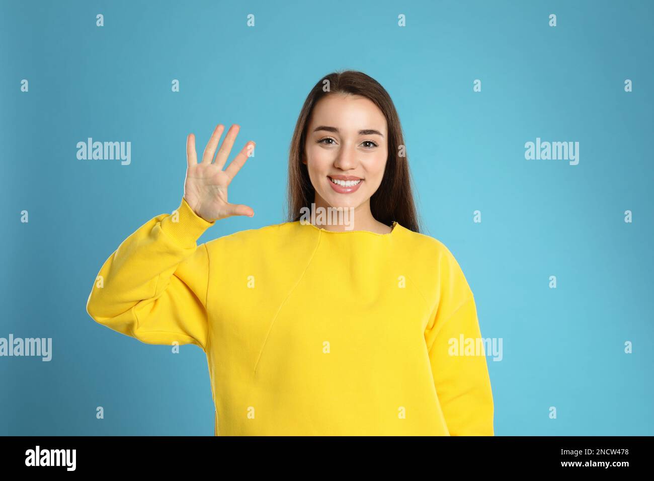 Woman showing number five with her hand on light blue background Stock ...