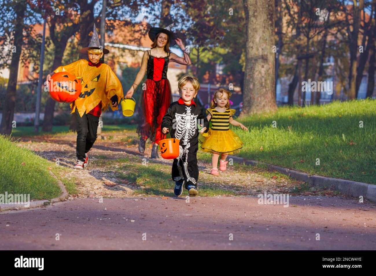 Woman with children run in Halloween costumes and scary pumpkin Stock ...