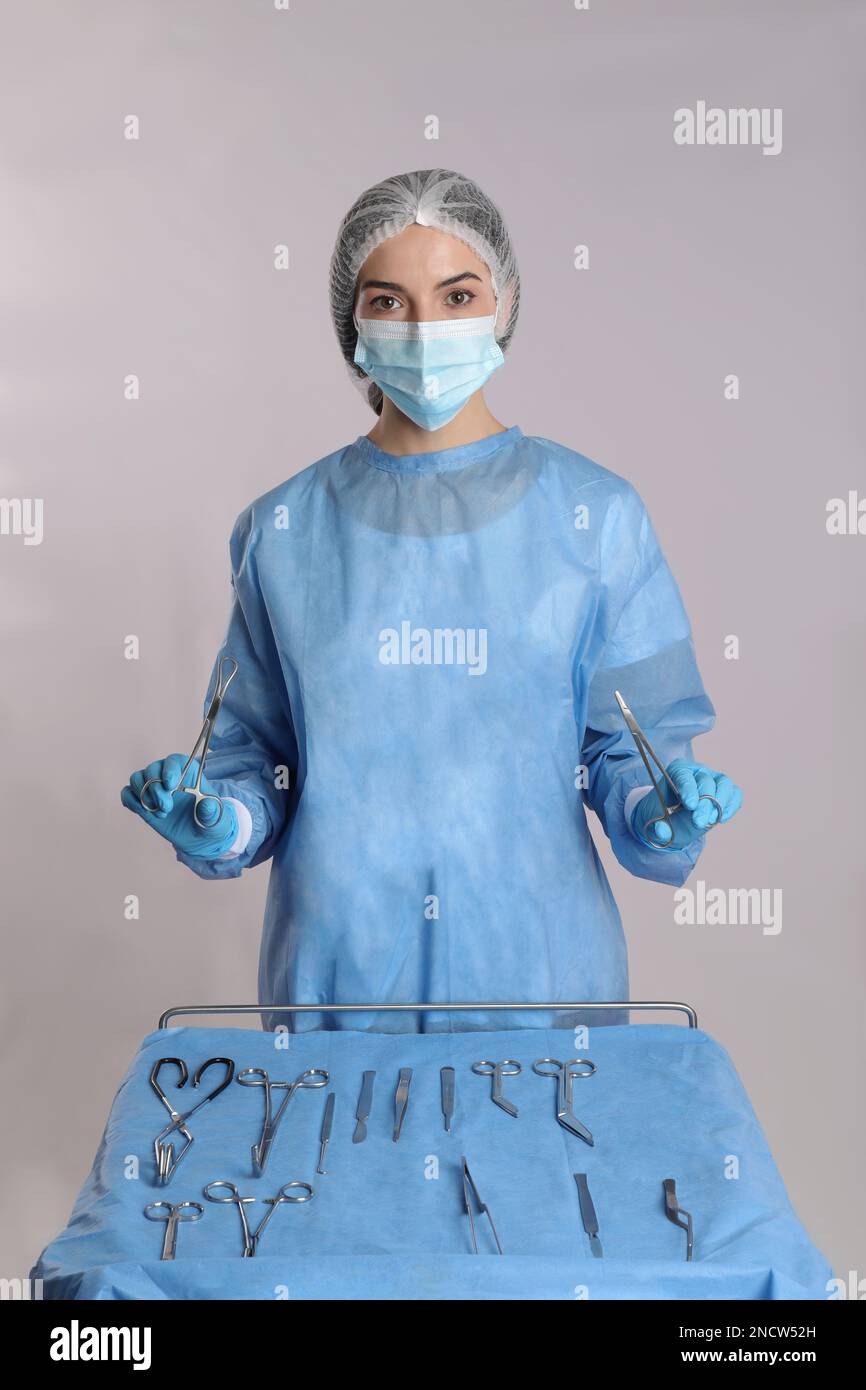 Doctor holding medical clamps near table with different surgical ...