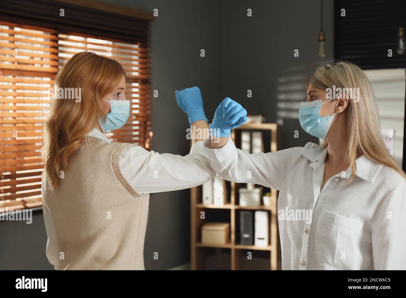 People greeting each other by bumping elbows instead of handshake ...