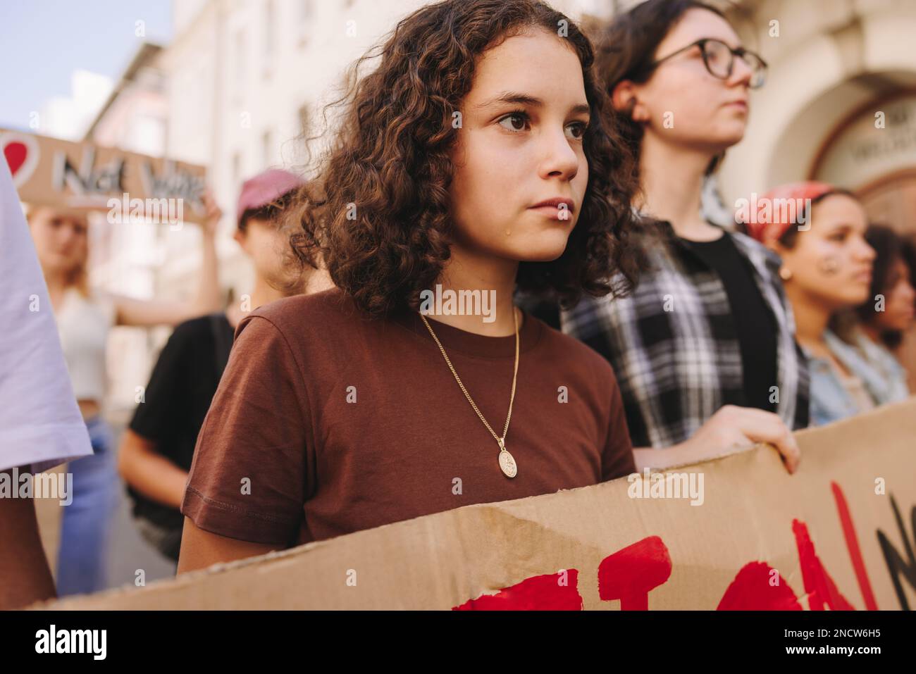 Diverse young people protesting against war and violence in the streets ...