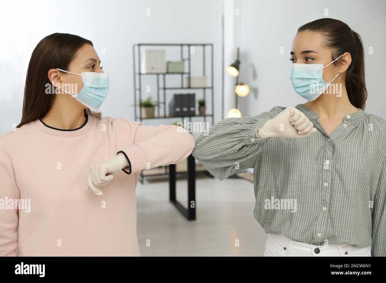 Women greeting each other by bumping elbows instead of handshake in ...
