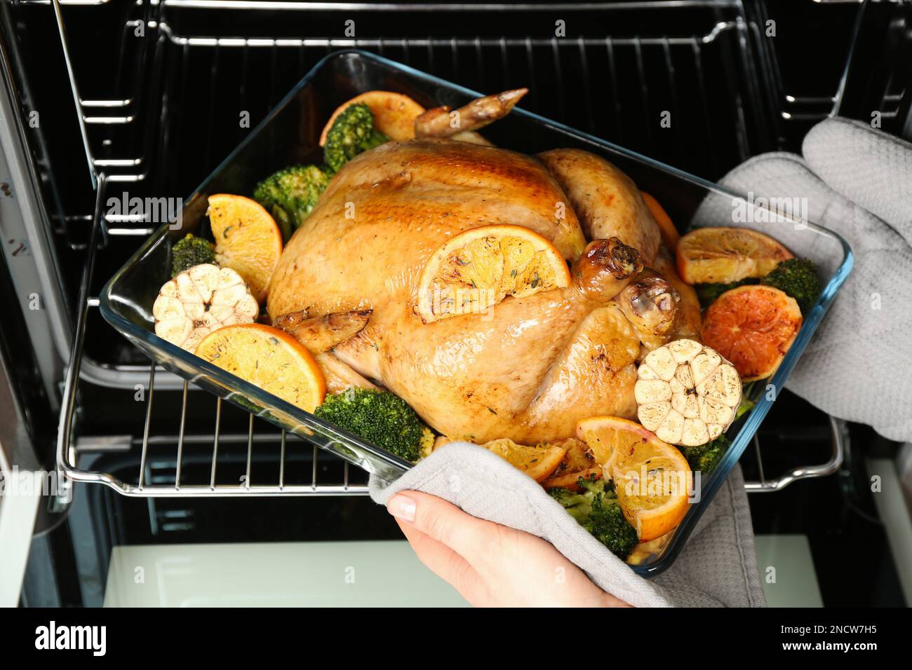 Woman taking baked chicken hi-res stock photography and images - Alamy