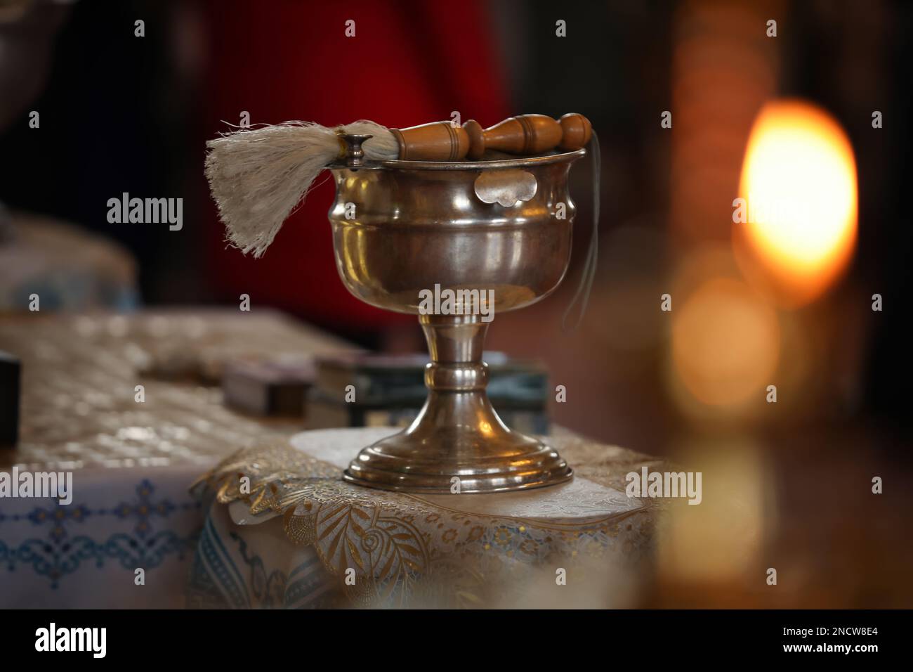 Silver vessel with holy water and brush on stand in church. Baptism ...