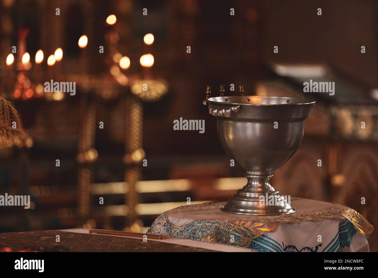 Silver vessel with holy water on stand in church, space for text ...
