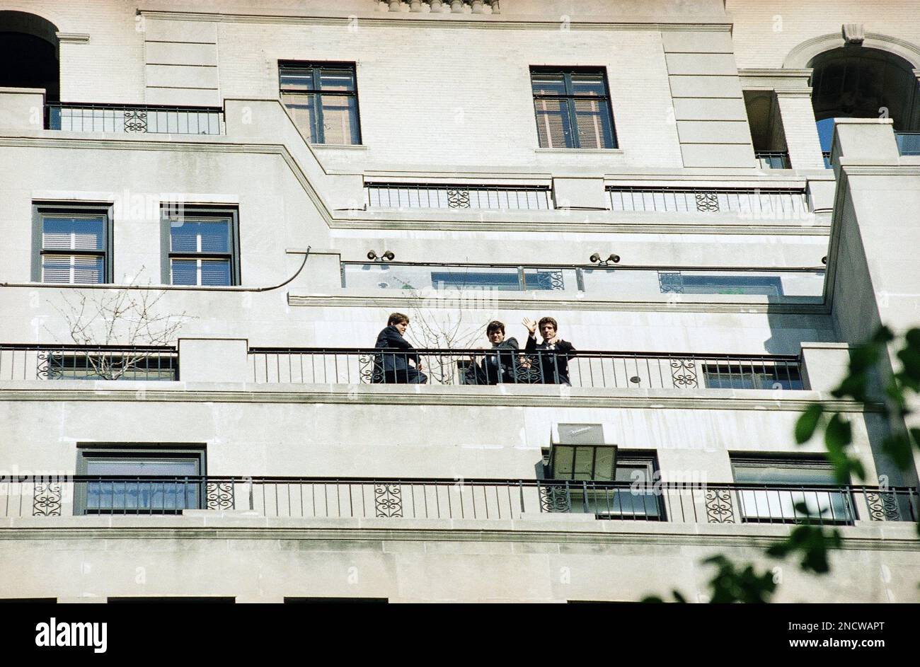 John F. Kennedy Jr., right, waves from the balcony to the crowds of ...