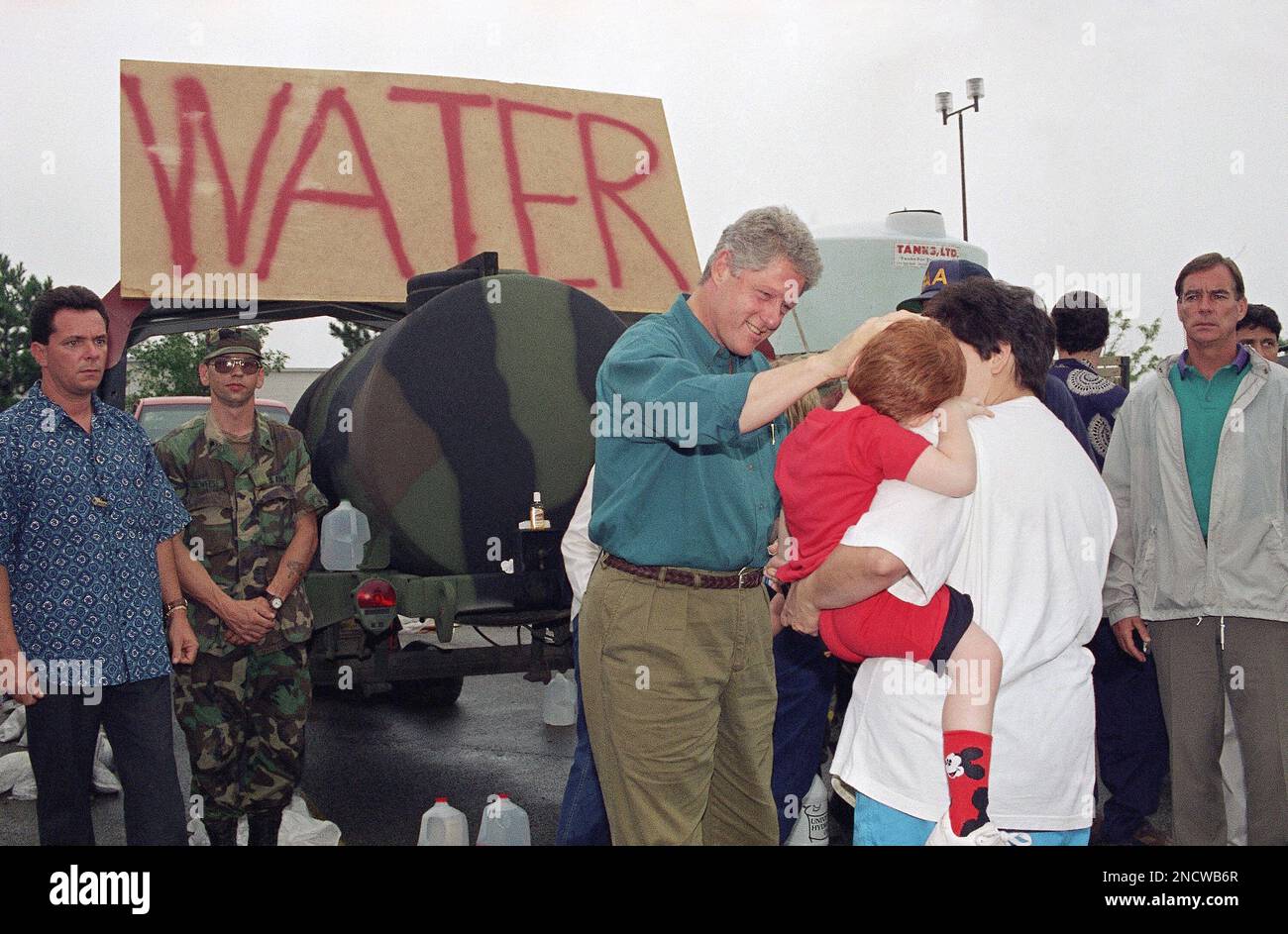 President Bill Clinton pats a child on the head while visiting a water ...