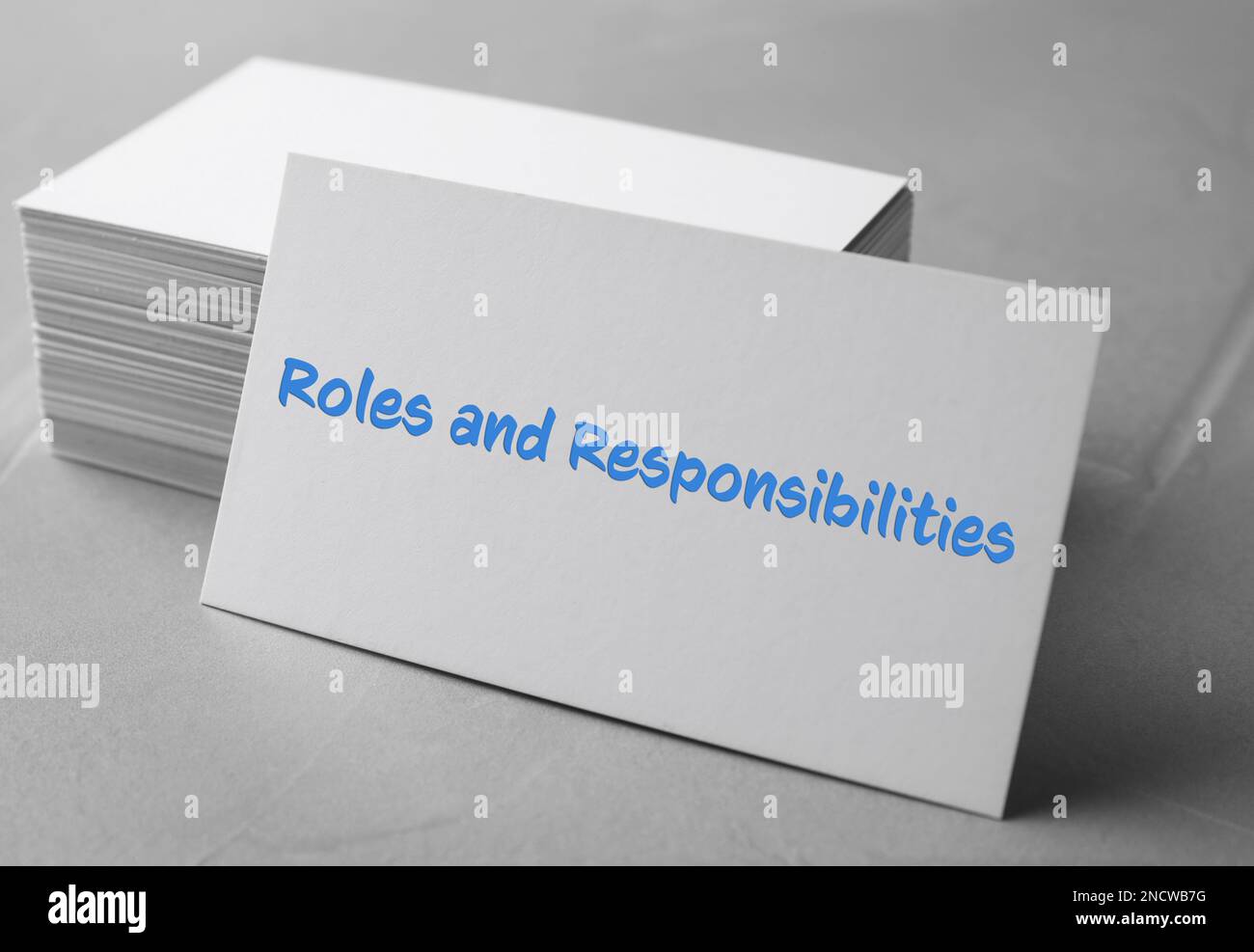 Sheet of paper with text Roles and Responsibilities on grey stone table ...