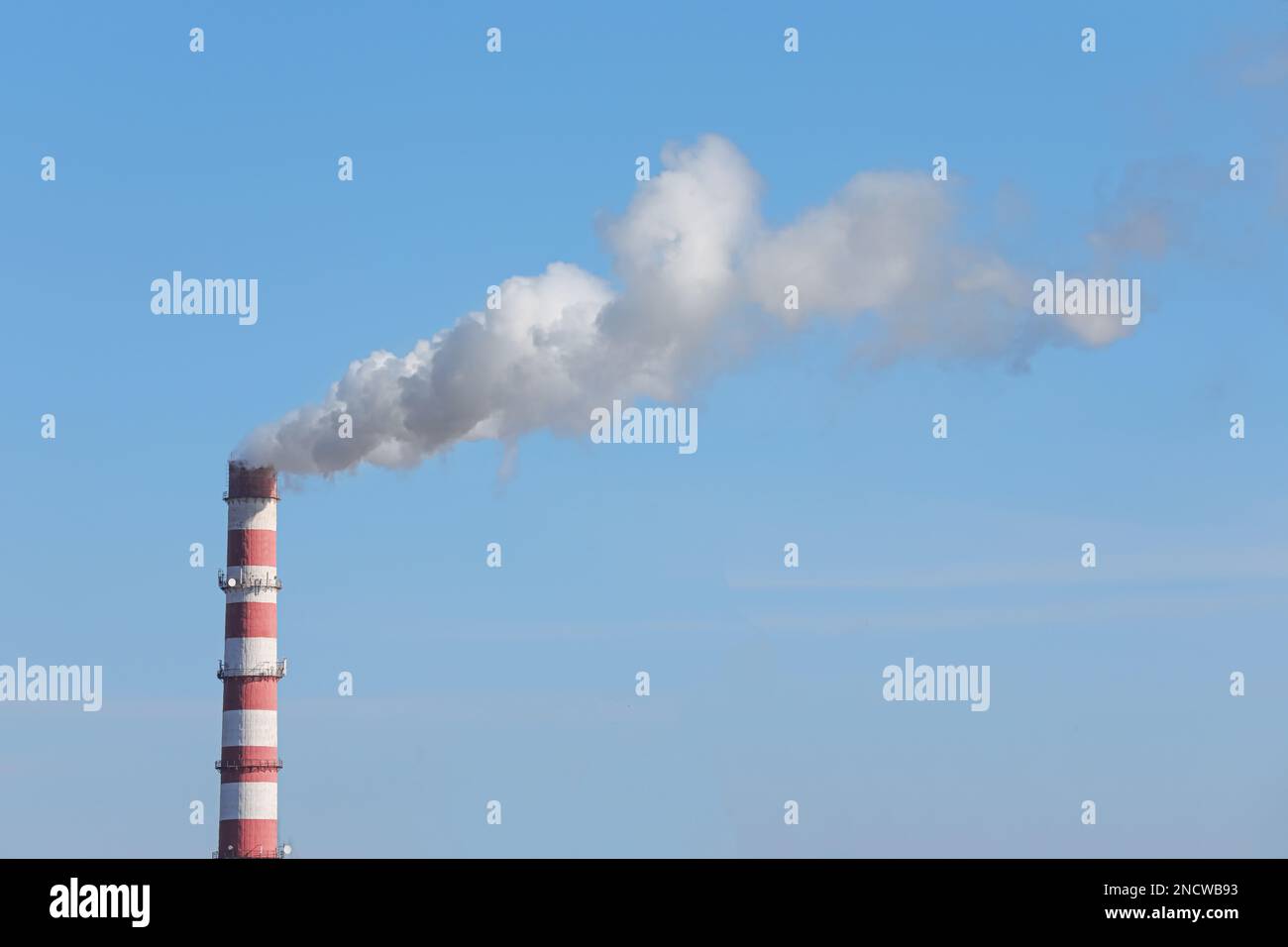 Polluting air with smoke from industrial chimney outdoors against blue ...