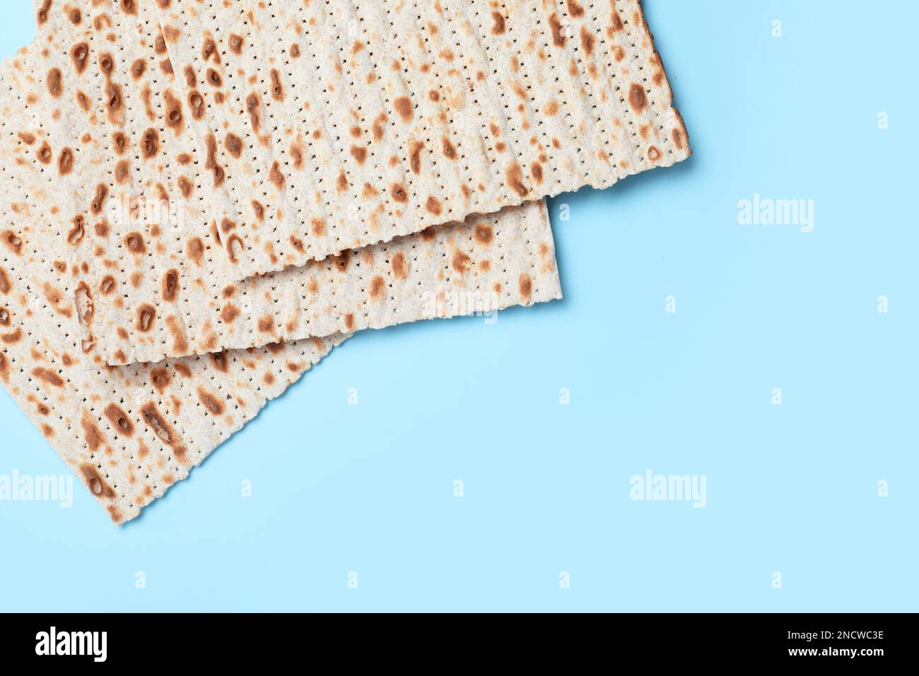 Traditional matzos on light blue background, flat lay. Space for text ...
