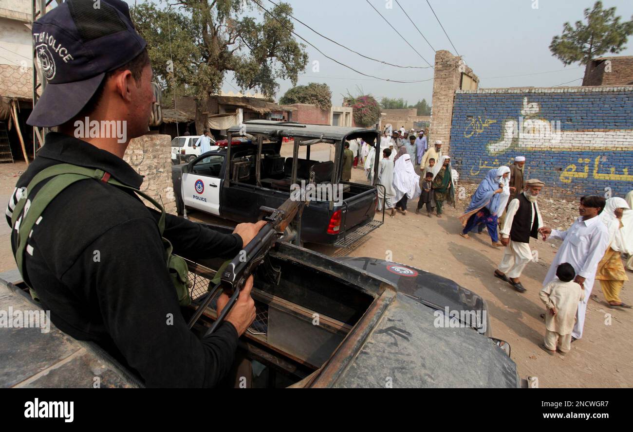 Pakistani police officers cordon off the area of a grenade attack on a ...