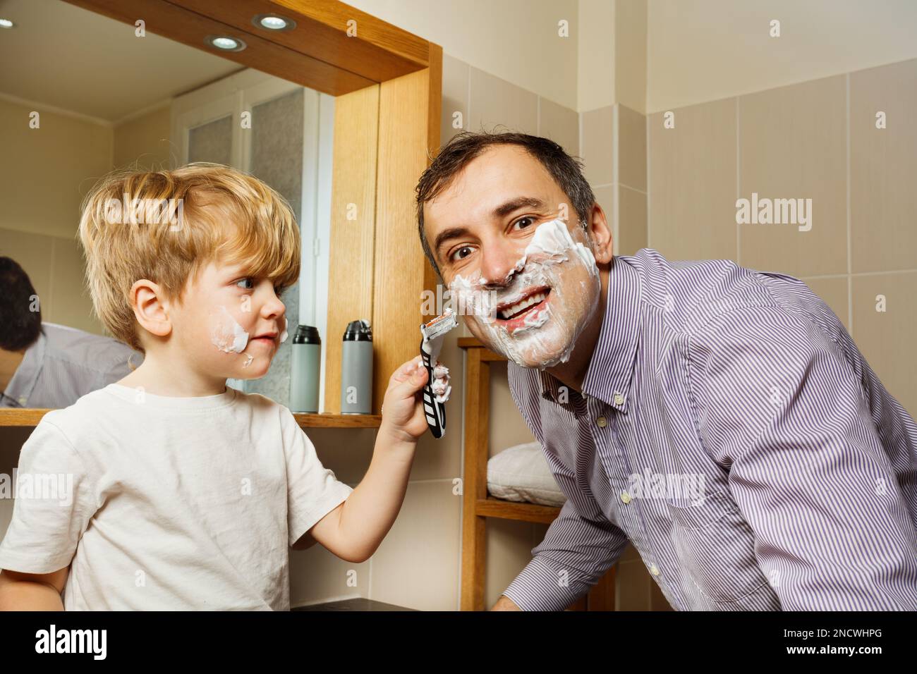 Dad shave in the morning with his son helping him holding razor Stock ...
