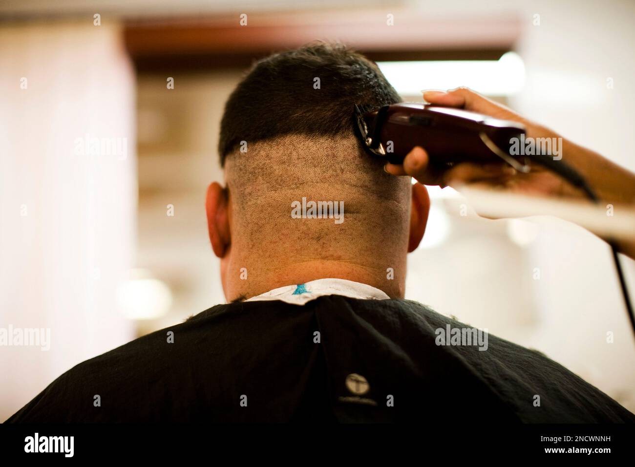 U.S. Army Sgt. 1st Class Stephen Roach, 16th MPAD, from El Paso, Texas, has a hair cut in a ...