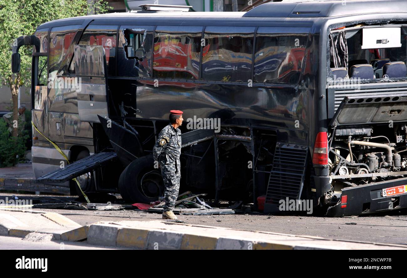 An Iraqi policeman inspects a destroyed bus in Baghdad, Iraq, Tuesday ...