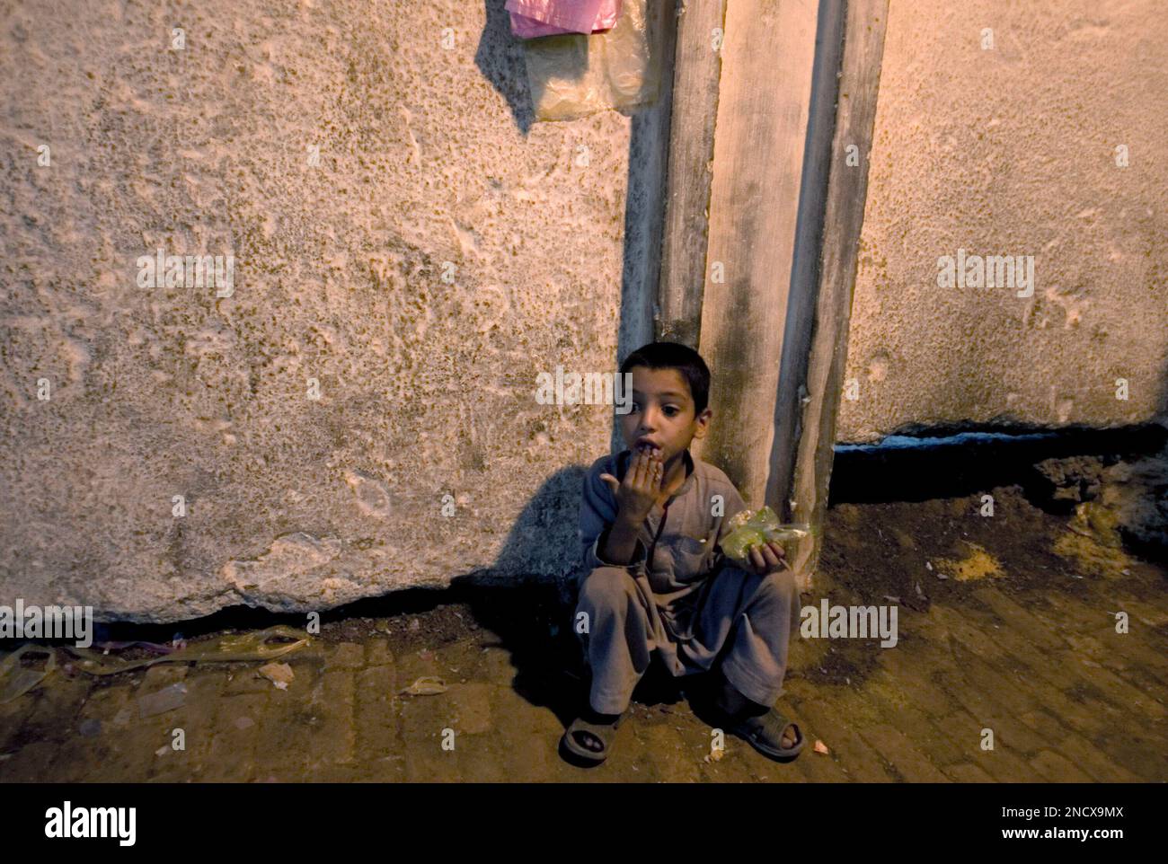 A Pakistani child eats rice outside free food distribution point at the ...
