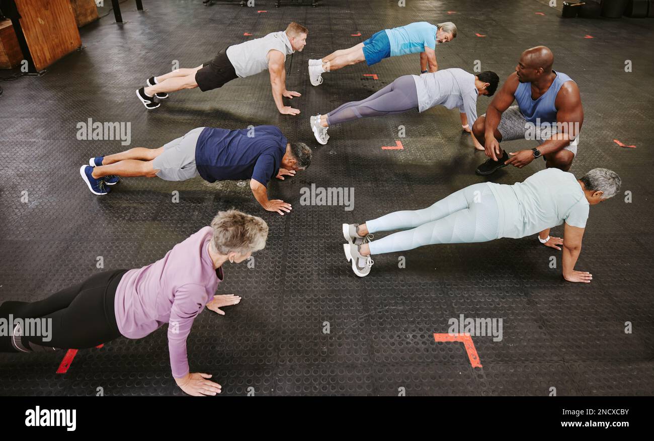People, fitness and stretching in class with personal trainer at gym ...