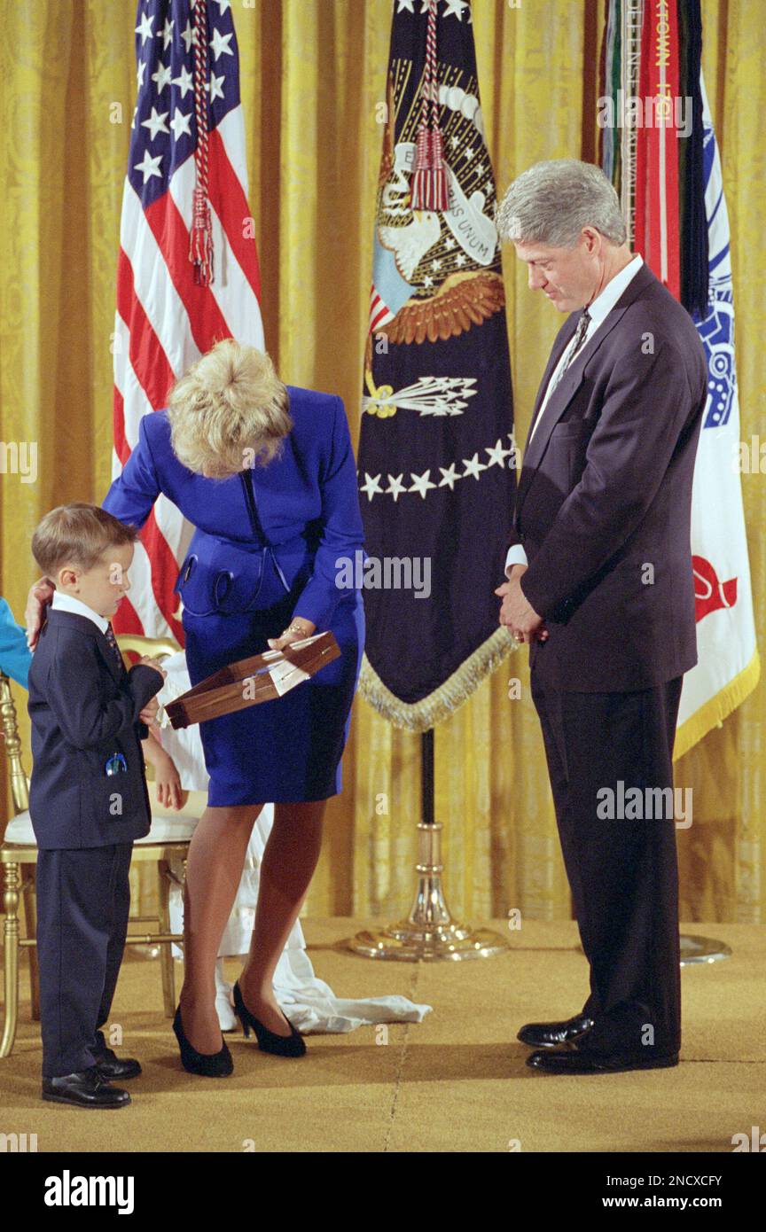 President Bill Clinton looks on as Carmen Gordon shows the Medal of ...