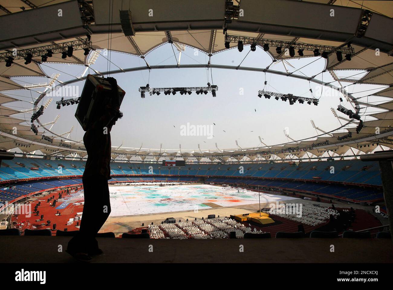 An Indian worker carries a box inside Jawaharlal Nehru Stadium, the ...