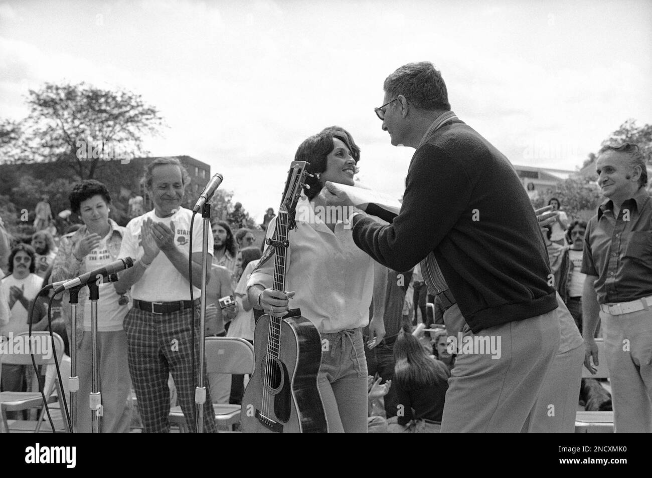 Folk singer Joan Baez (with guitar) receives the thanks from parents of ...