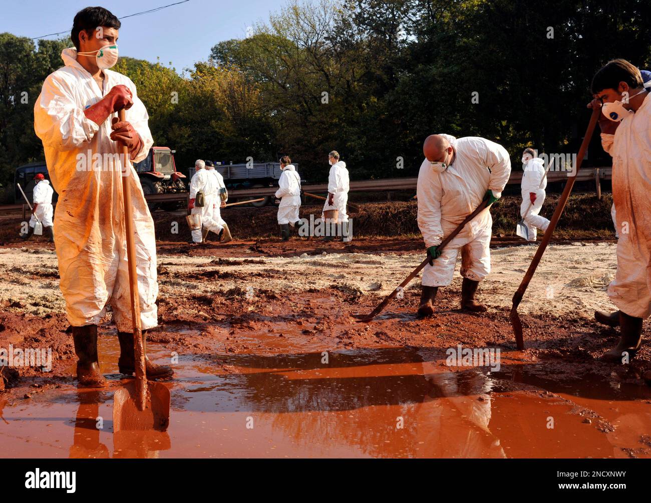 Volunteers wearing protective clothing clean streets covered by toxic ...