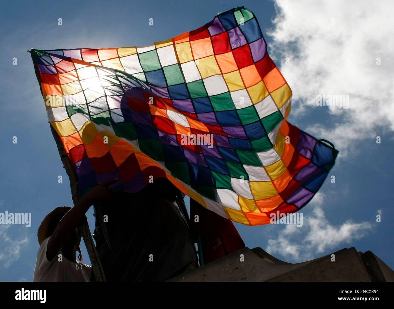 An indigenous man covers a statue of South America's Independence hero ...