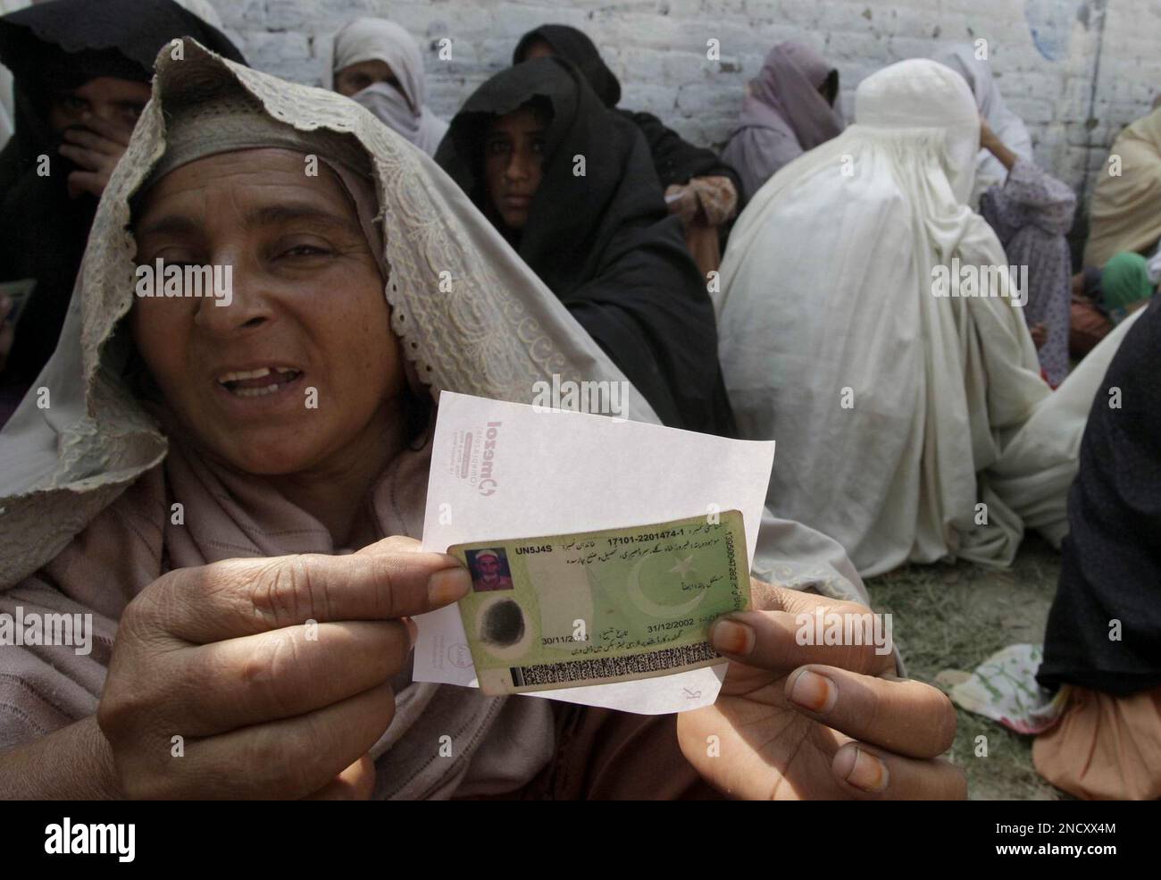 A Pakistani woman who is affected by floods shows her relative's ...