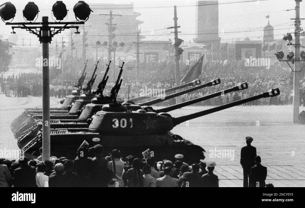 Four red Chinese-built tanks, with guns raised, parade in Beijing ...