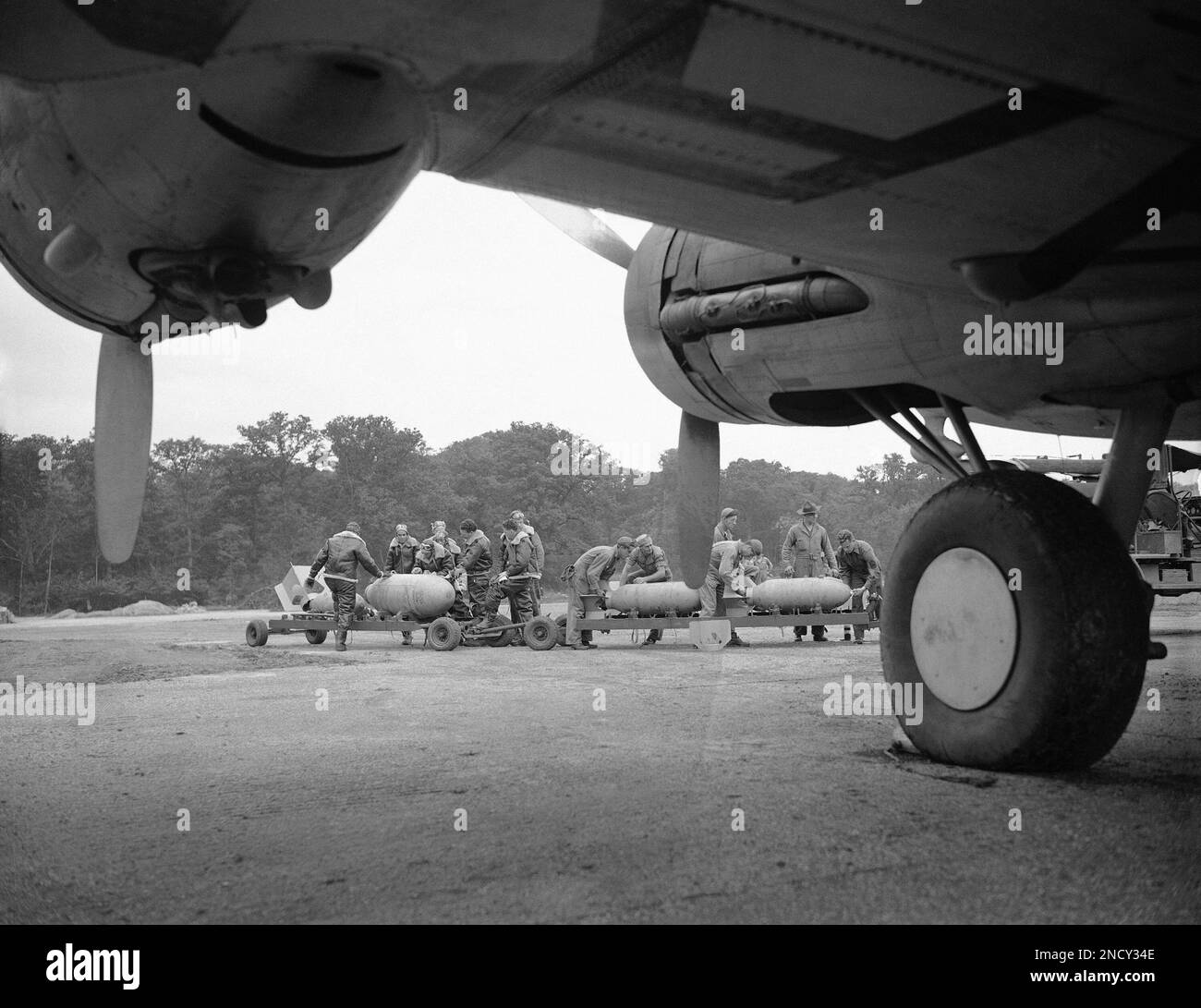 Bombing up. The ground crews wheel the bomb trolleys under the giant ...