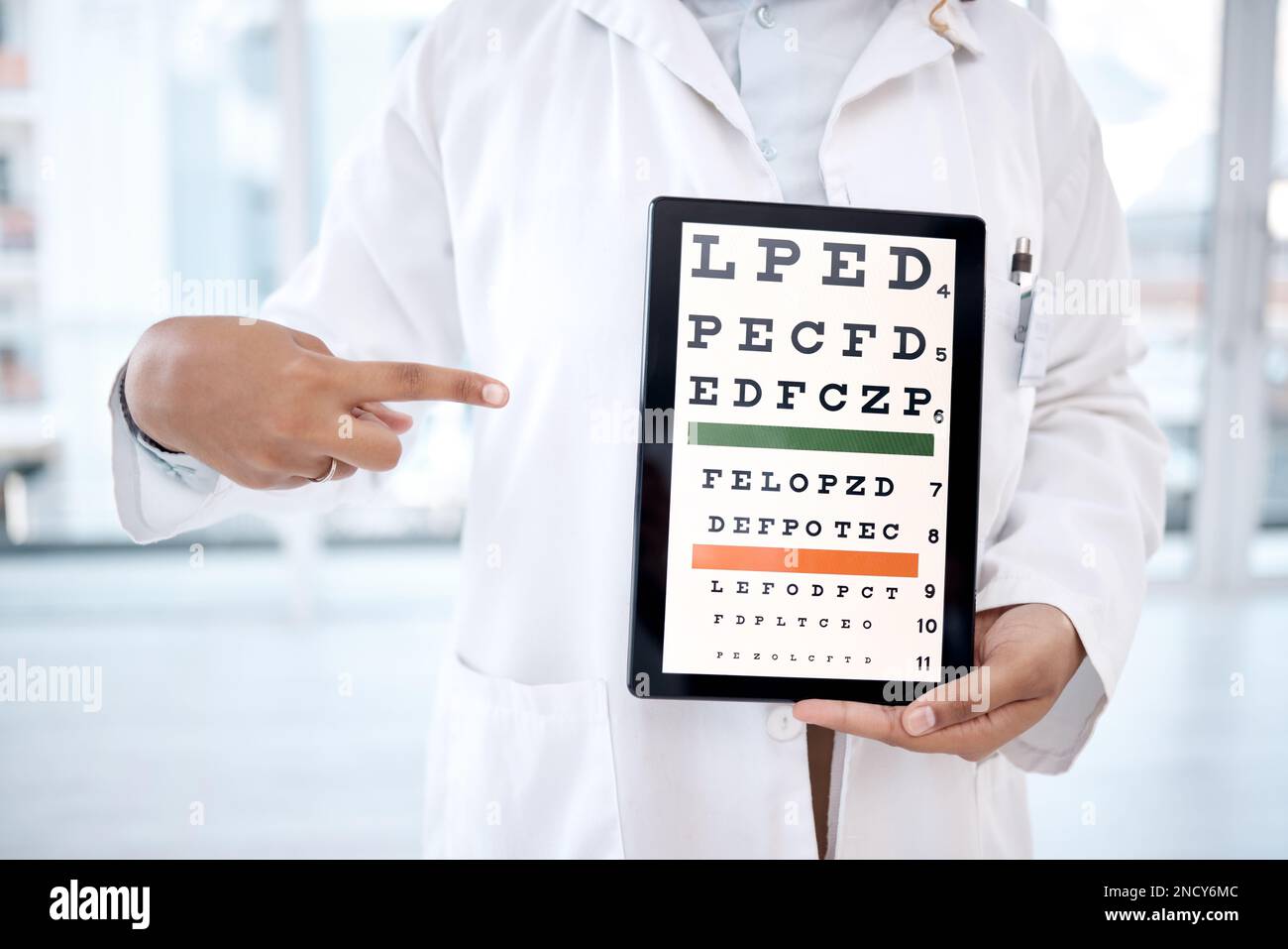 Hands, tablet screen and eye chart in hospital for vision examination ...