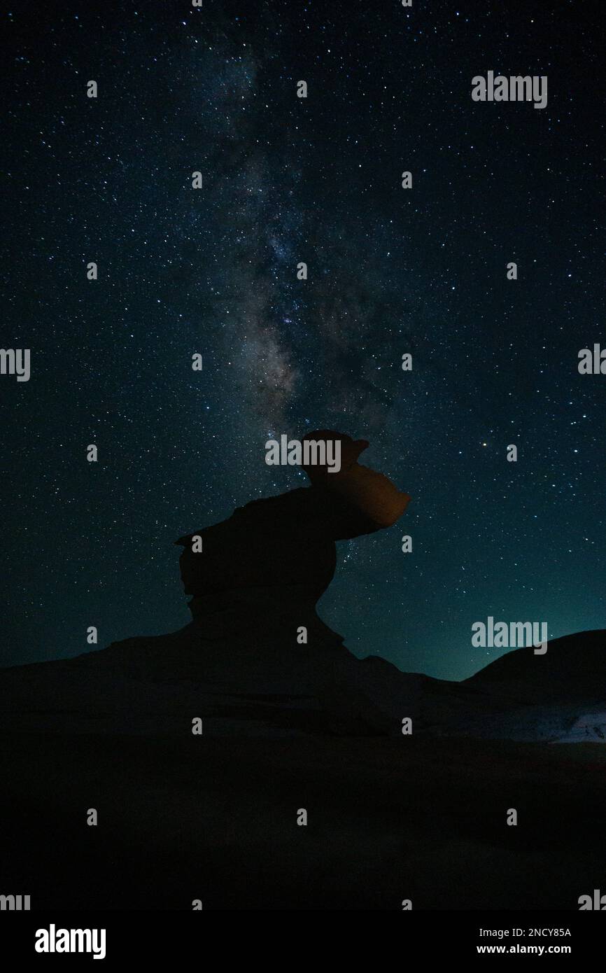 A stunning natural rock formation illuminated by a night sky filled ...