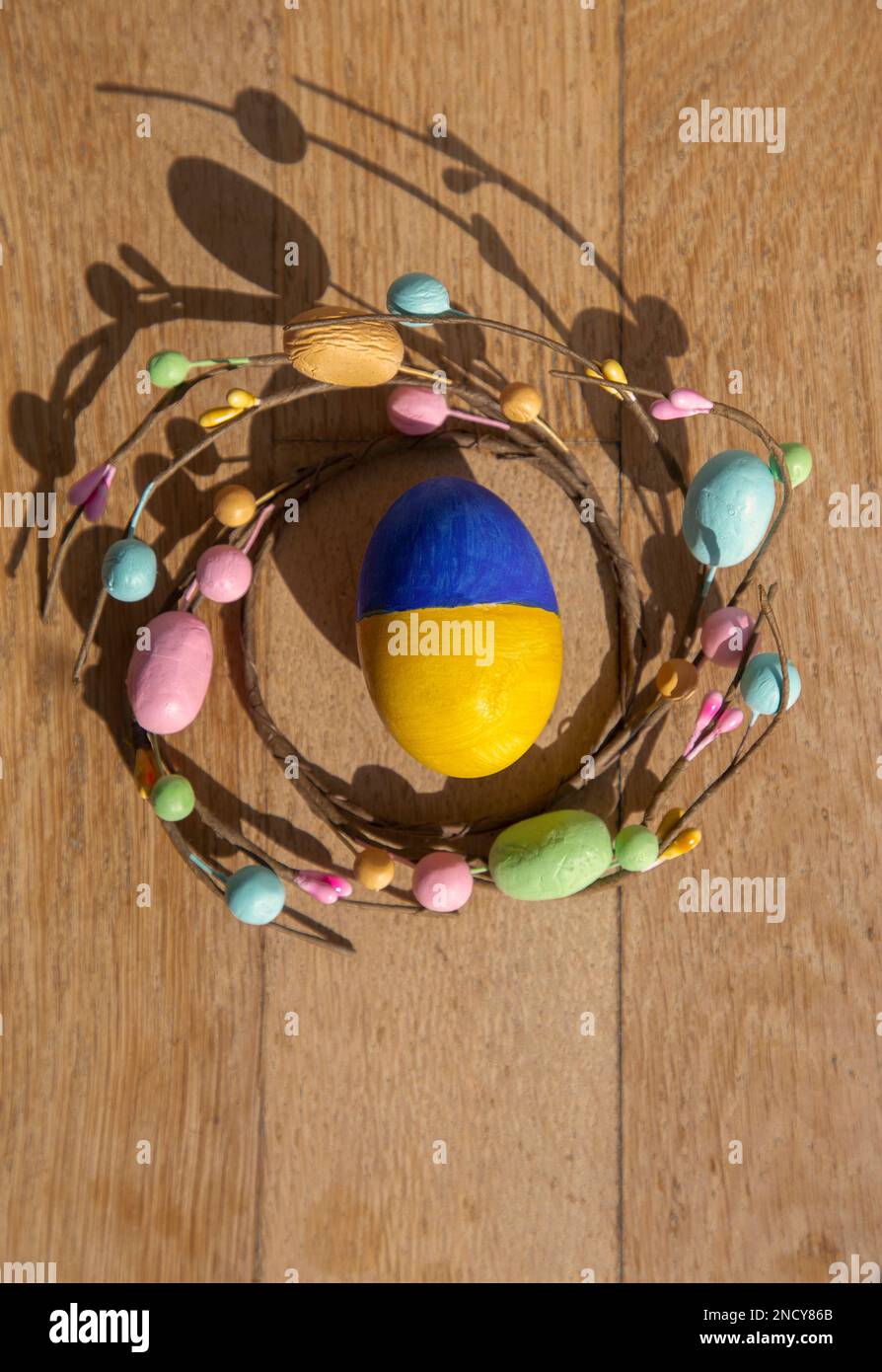 one Easter egg is painted in half in yellow and blue colors of the ...