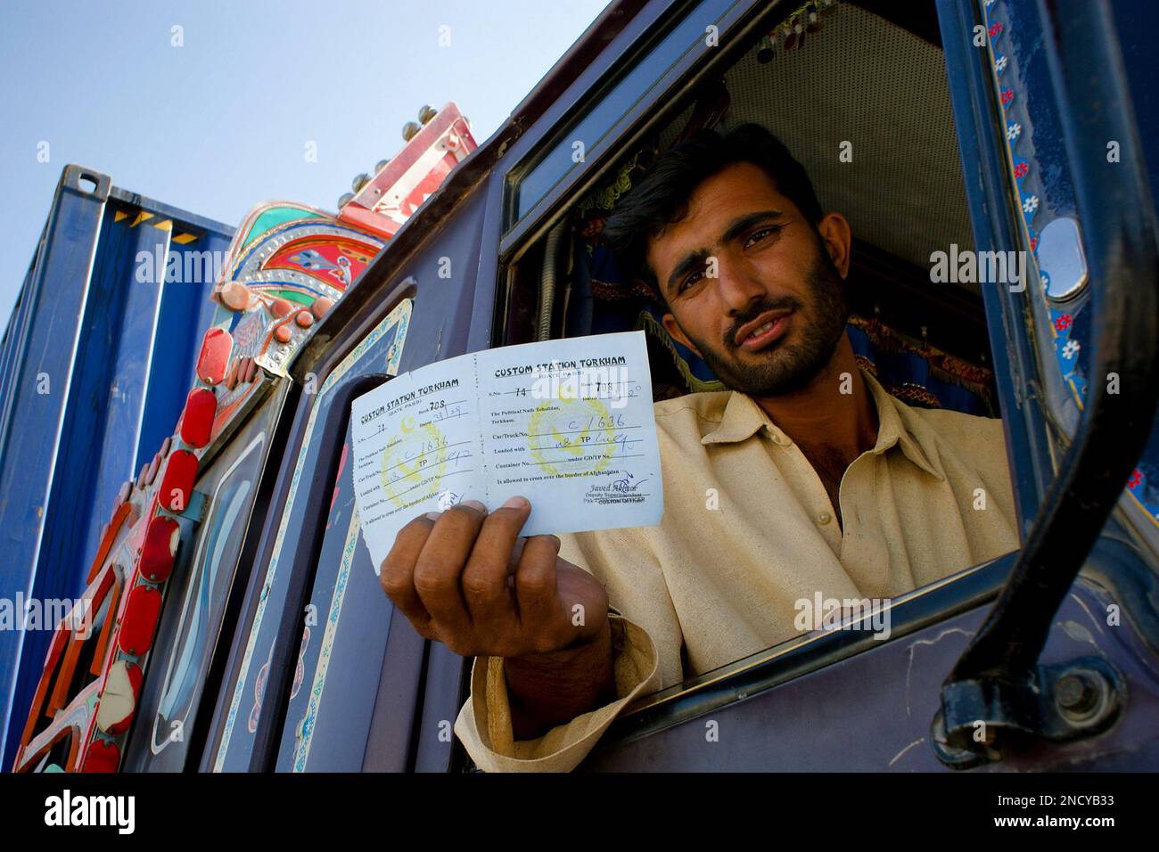 A Pakistani truck driver shows custom pass to enter into Afghanistan ...
