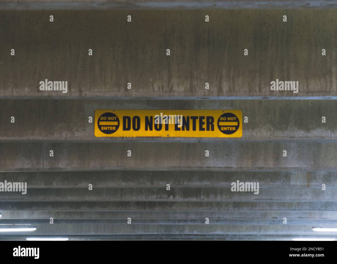 A low-angle of "do not enter" yellow sign hanging from the roof indoors ...