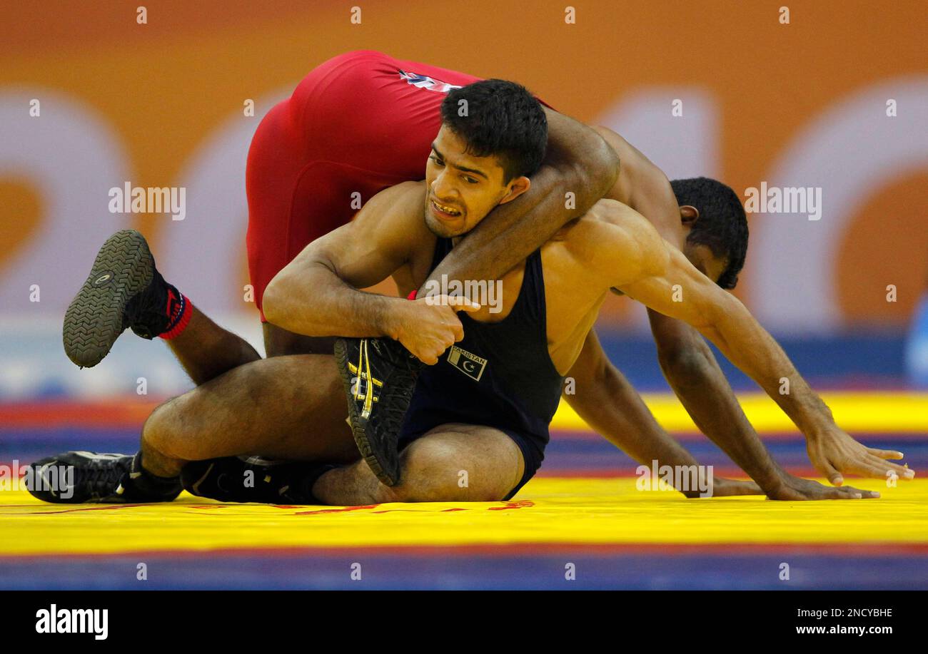 Sri Lankan wrestler Roshan Indika Liyangae, in red, and Pakistan's ...