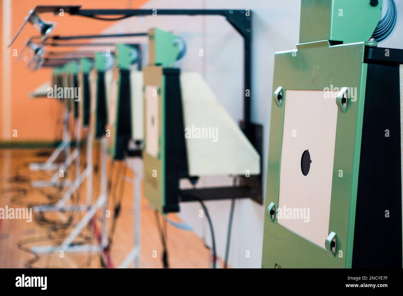 A line of green metallic booths indoors with light making shadows on ...