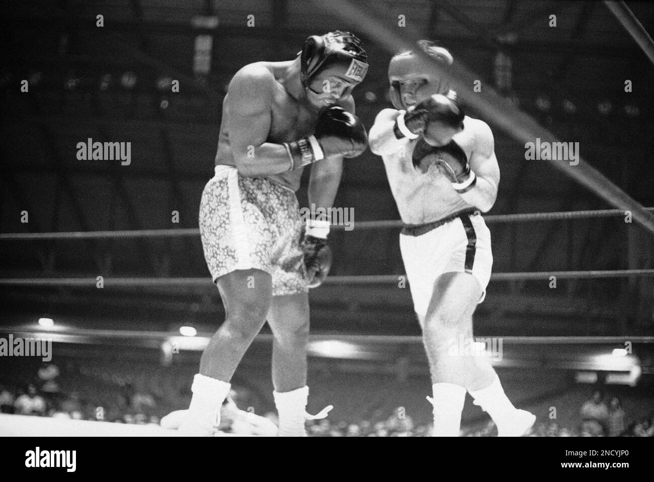 World Heavyweight Champion Joe Frazier, right, with his arms hanging as ...