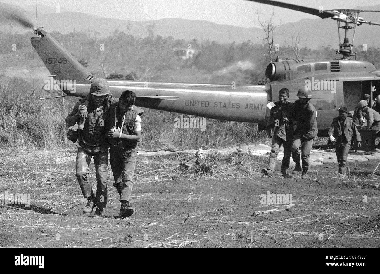Two wounded South Vietnamese soldiers are helped from a U.S. helicopter ...