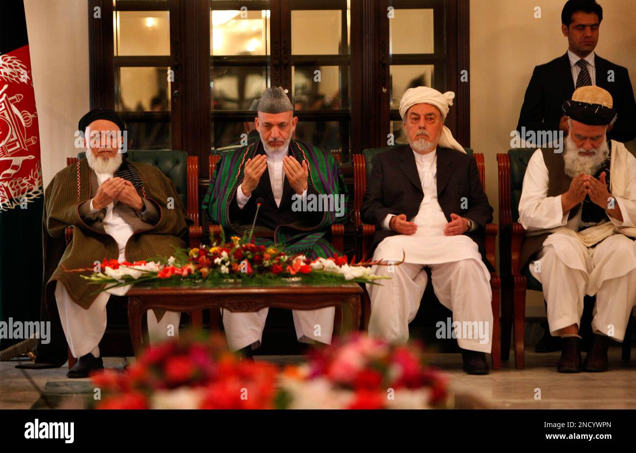 Afghan President Hamid Karzai, second left, prays with members of the ...