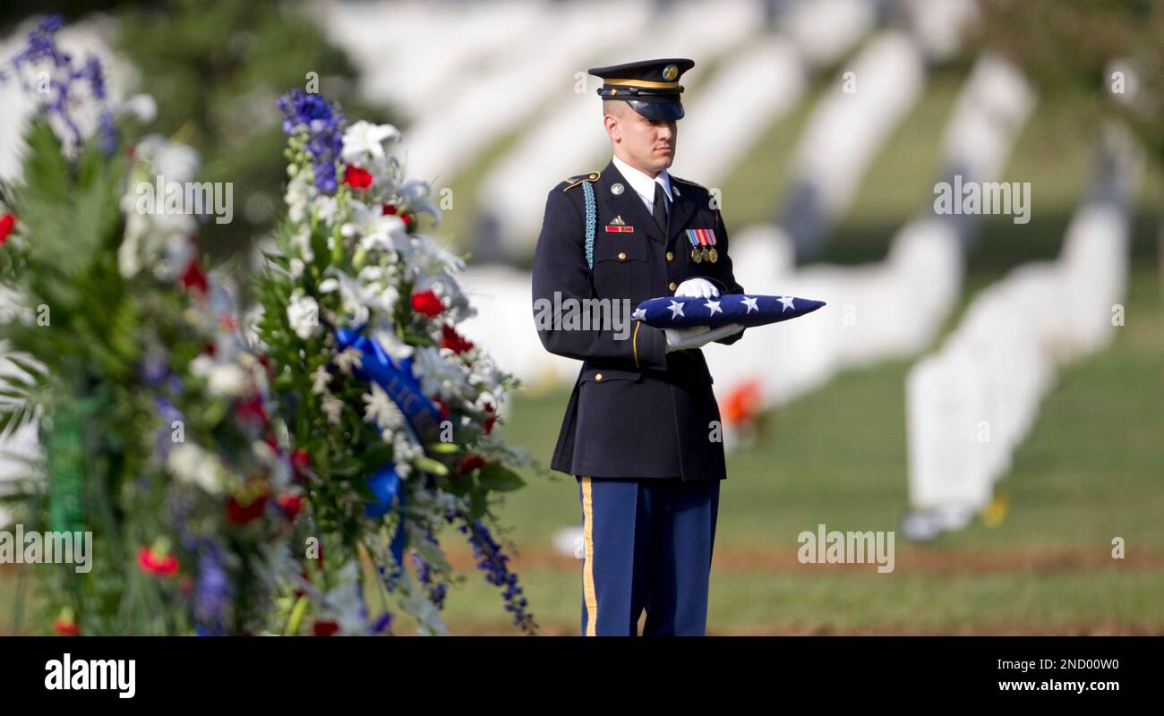 A member of an Army honor guard holds a flag to be presented to the ...
