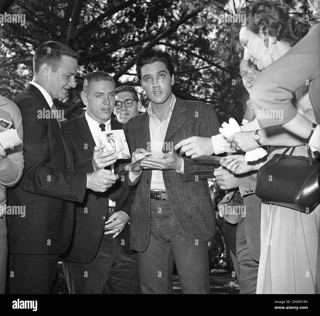 Members of Duke University’s football team cluster around Elvis Presley ...